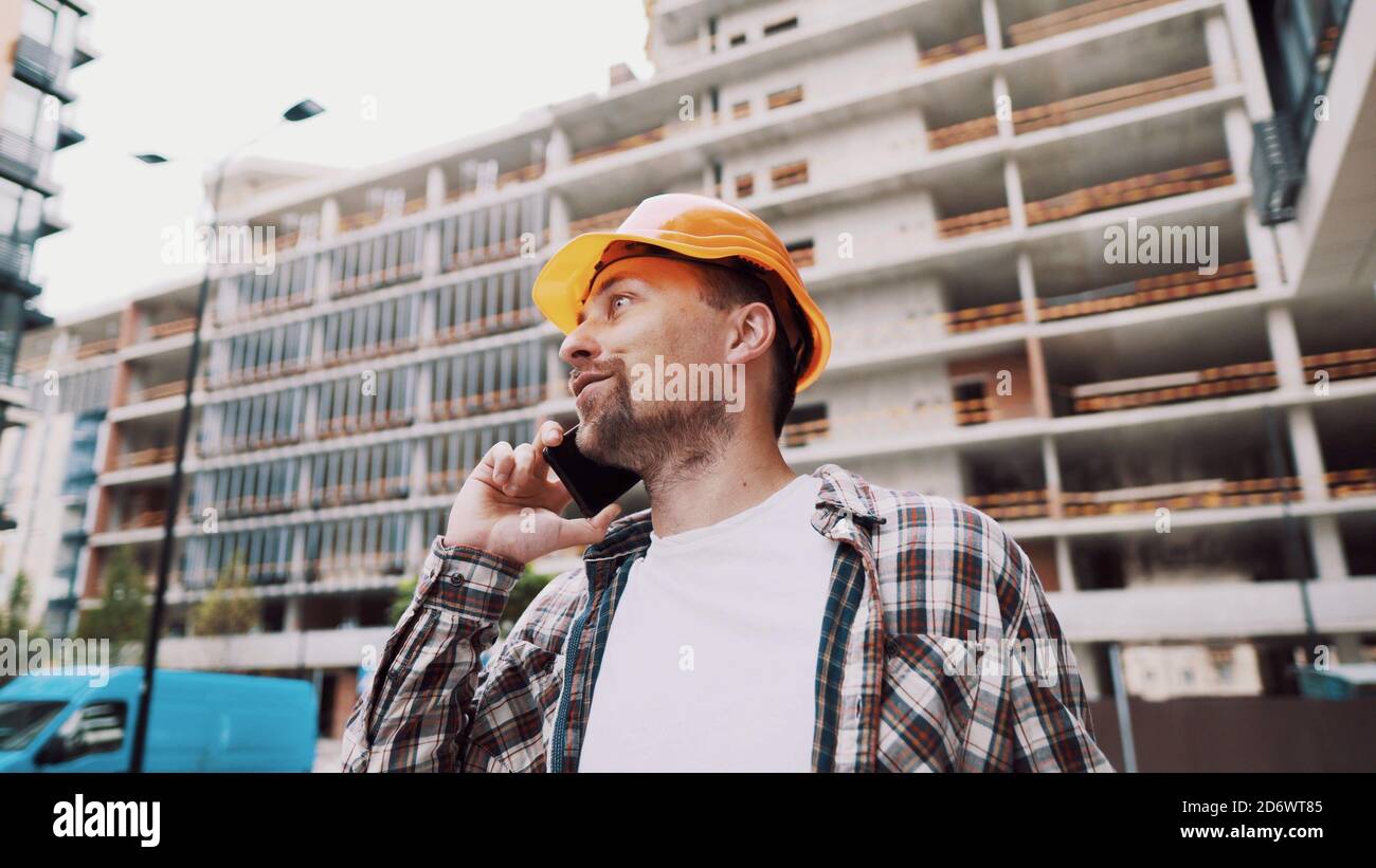 Engineer talking on phone. Architect using phone on construction site ...