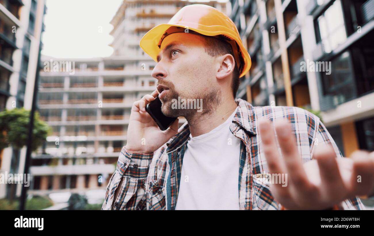 Engineer talking on phone. Architect using phone on construction site ...