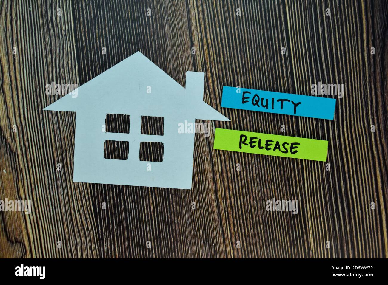 Equity Release write on sticky note and house made from paper isolated ...