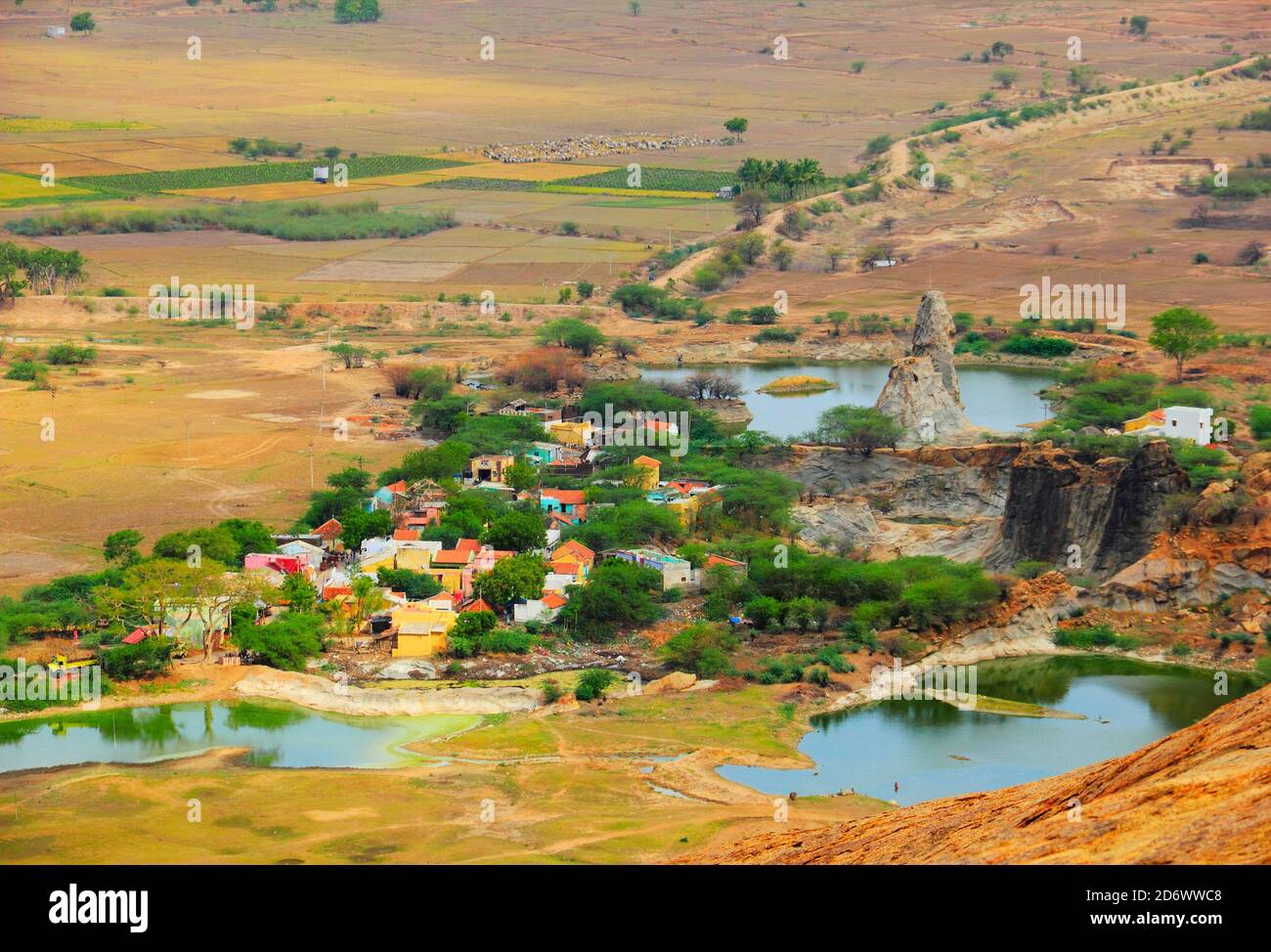 Aerial landscape of small hindu village surrounded by trees, lakes, colorful fields and meadows ...