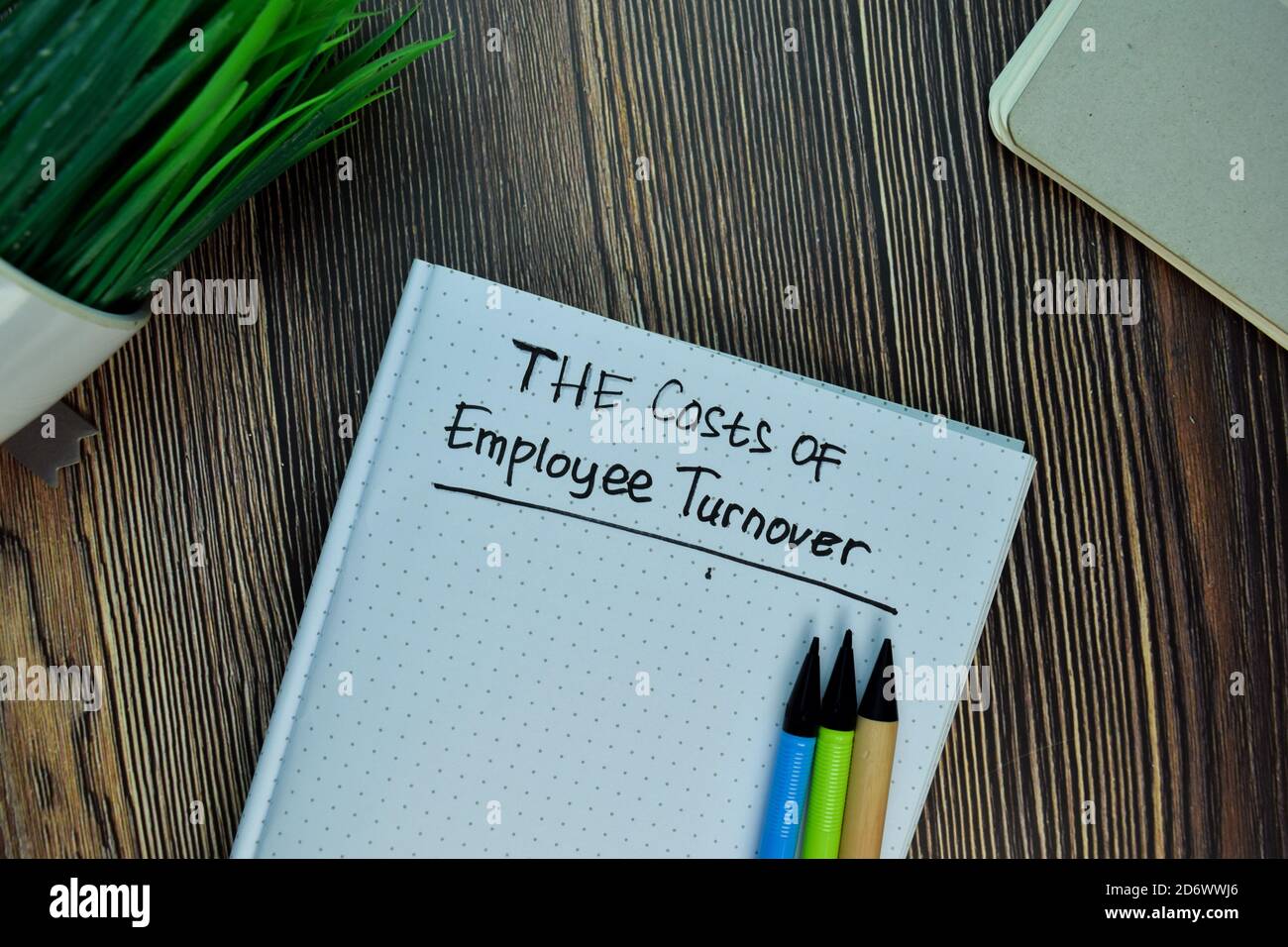 The Costs of Employee Turnover write on a book isolated on Wooden Table ...