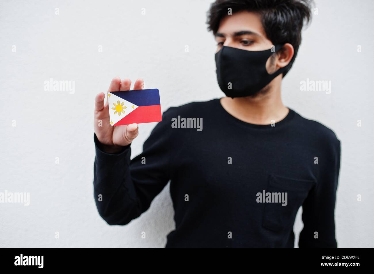 Asian man wear all black with face mask hold Philippines flag in hand ...