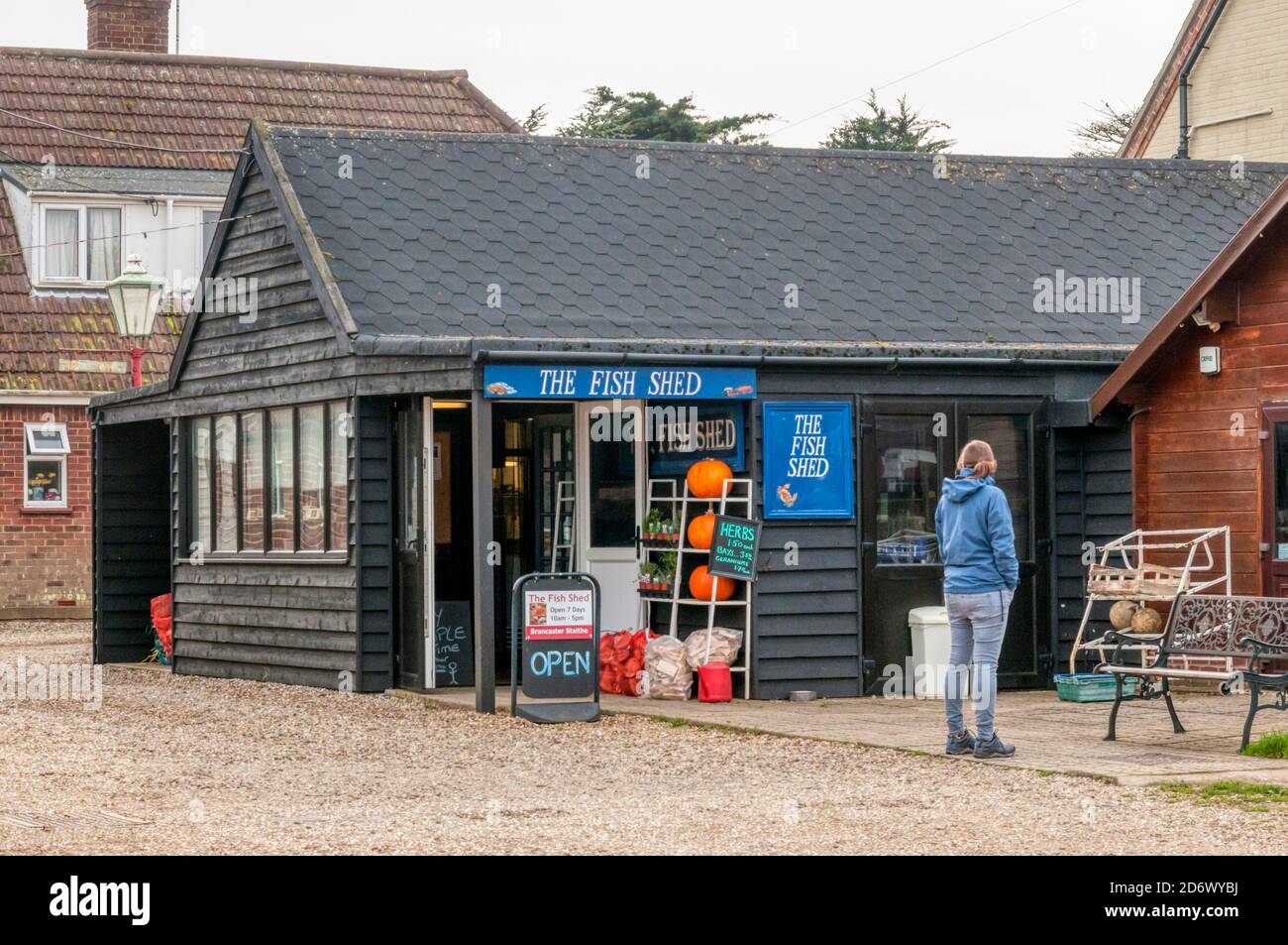 A customer waiting outside The Fish Shed at Brancaster Staithe on the ...