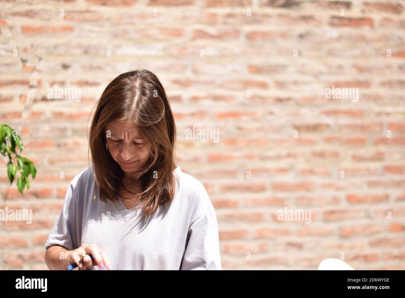 Woman checking her mobile phone with concern outdoors Stock Photo - Alamy