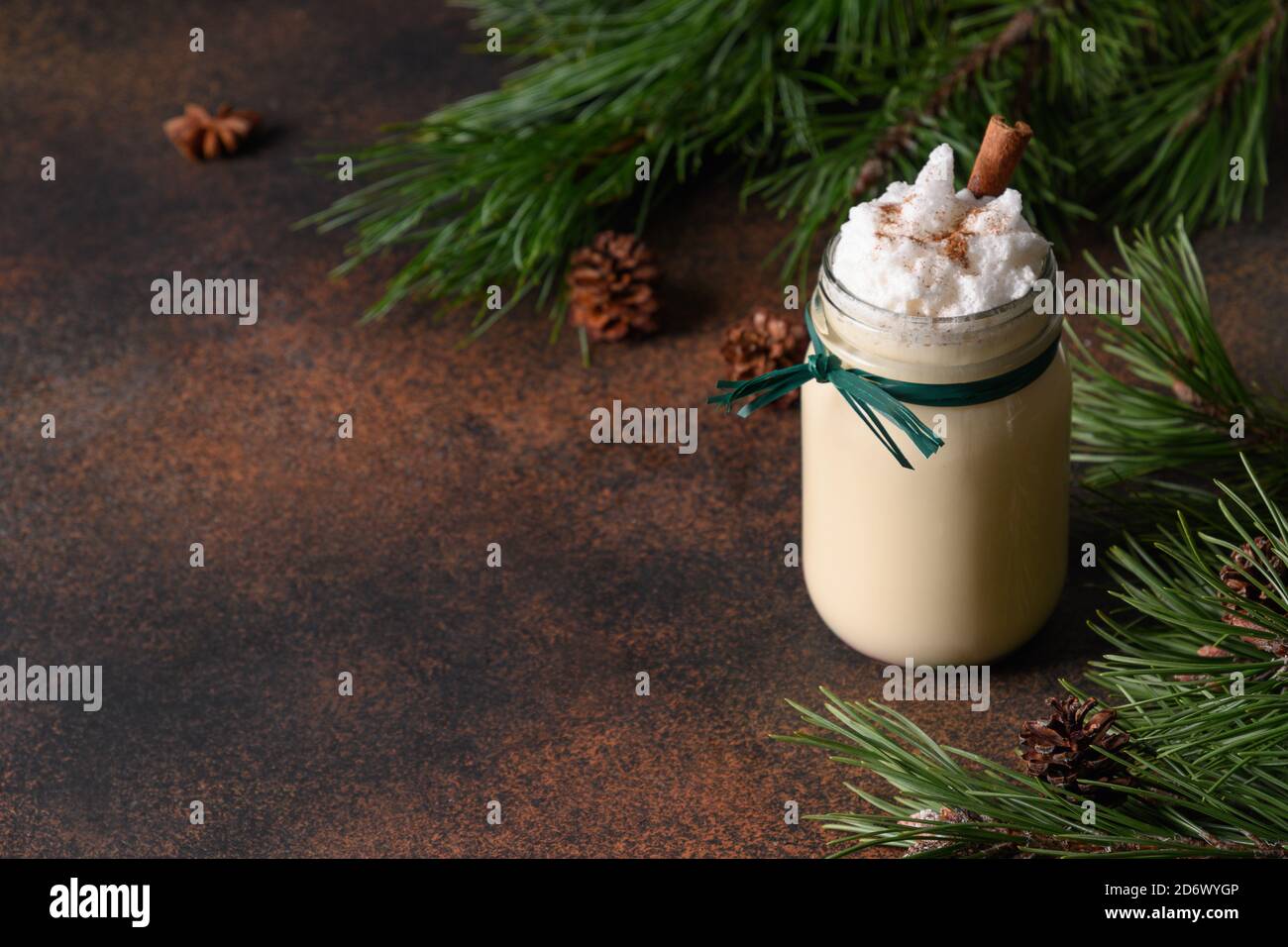 Christmas holiday eggnog in mason jar with cinnamon decorated fir tree ...