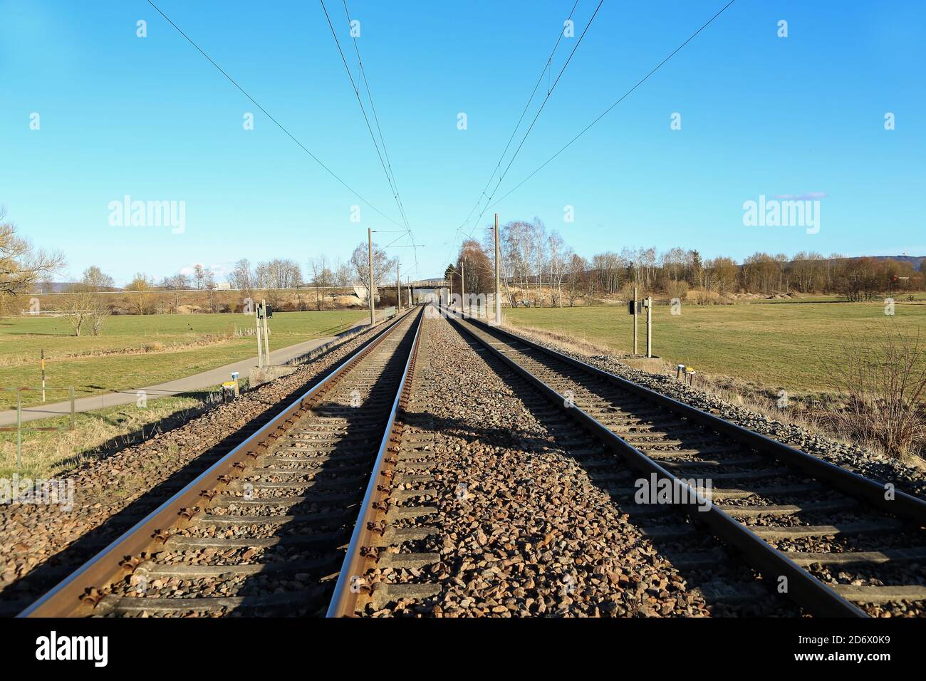 Railway stretching into the distance of green fields on a hot sunny day under the blue sky Stock ...