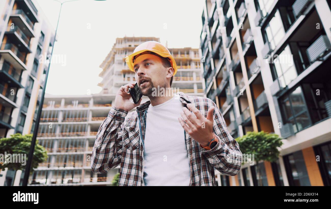 Engineer talking on phone. Architect using phone on construction site ...