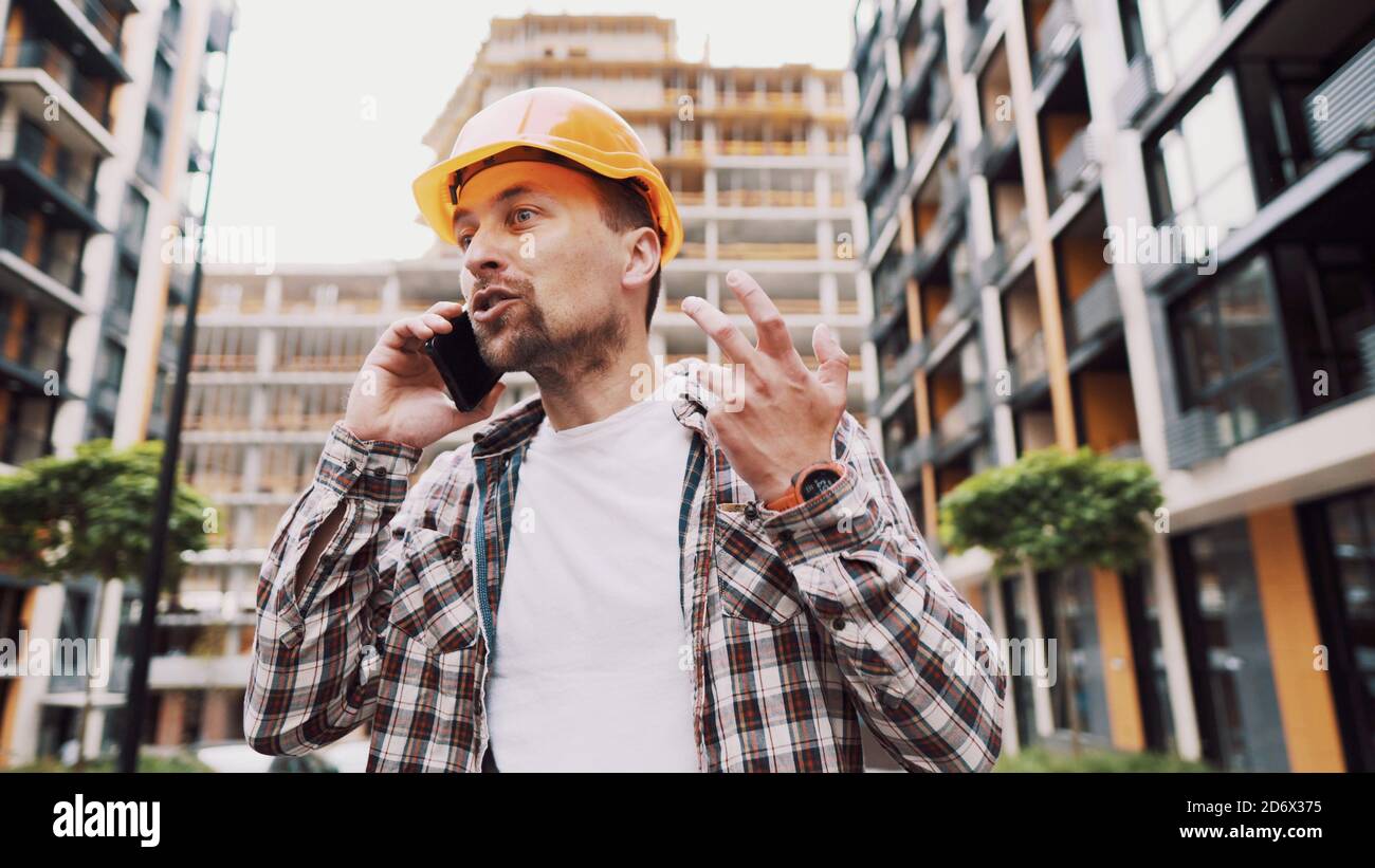 Engineer talking on phone. Architect using phone on construction site ...