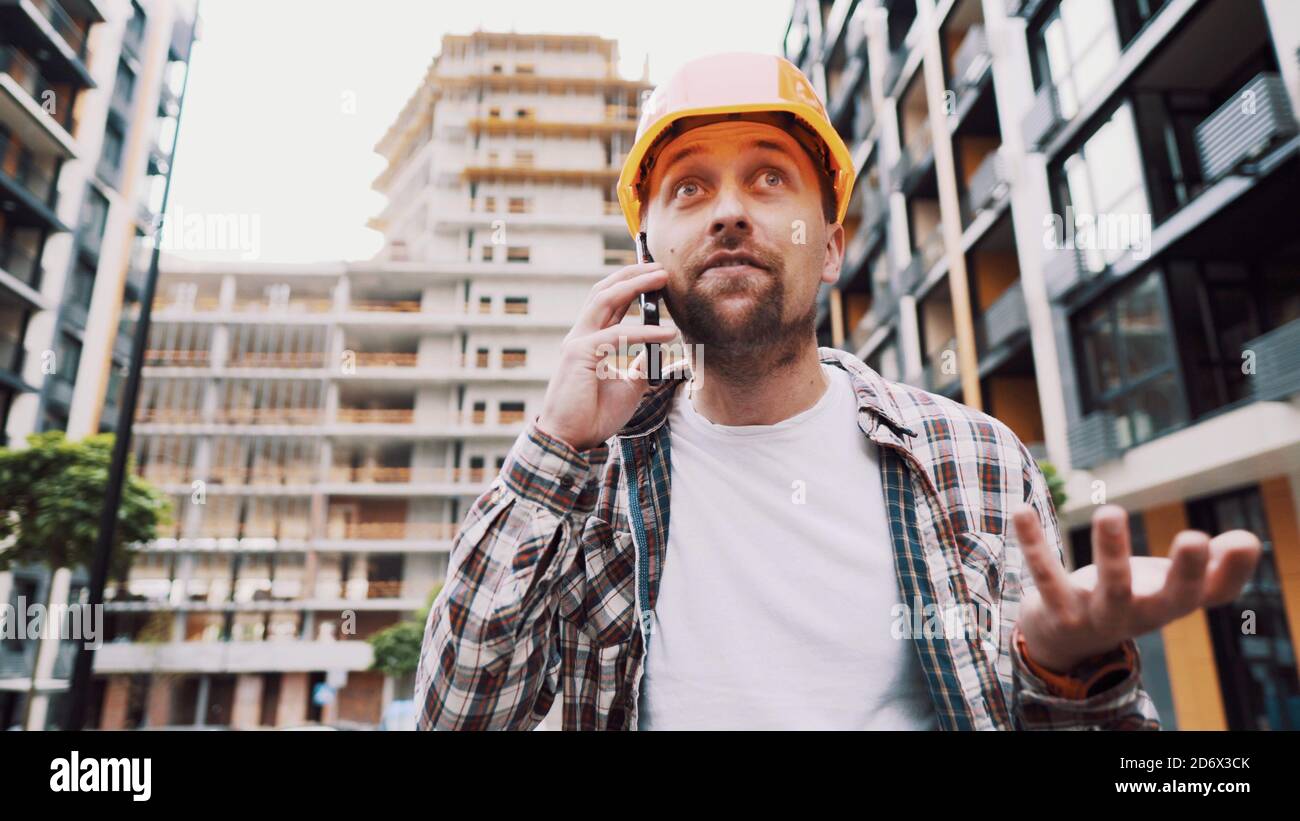 Engineer talking on phone. Architect using phone on construction site ...