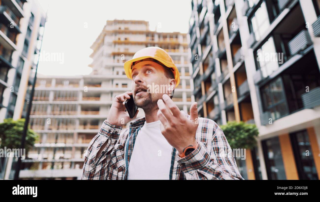 Engineer talking on phone. Architect using phone on construction site ...