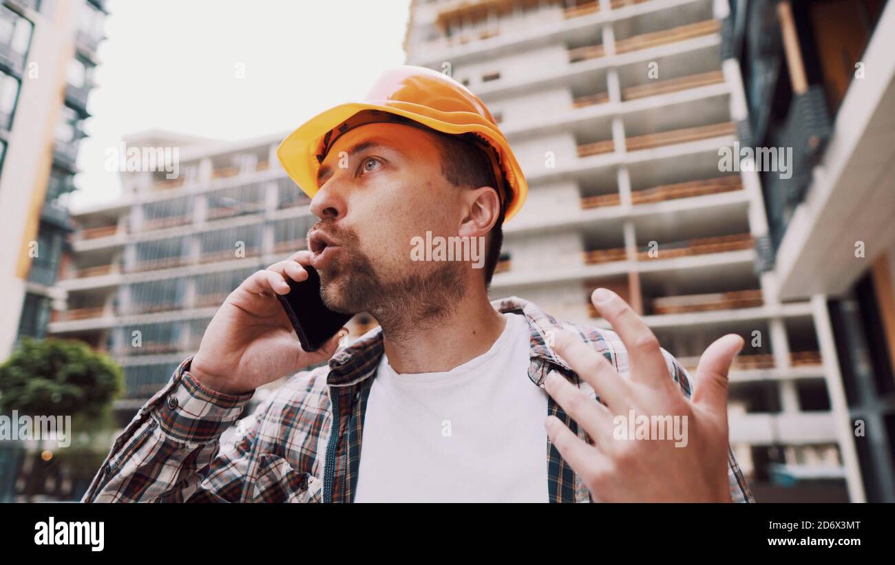 Engineer talking on phone. Architect using phone on construction site ...