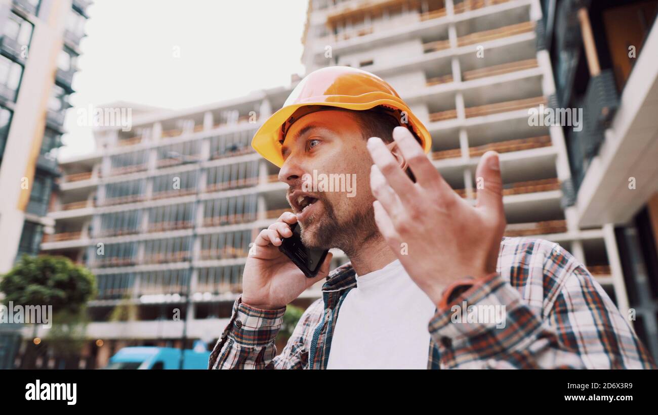 Engineer talking on phone. Architect using phone on construction site ...