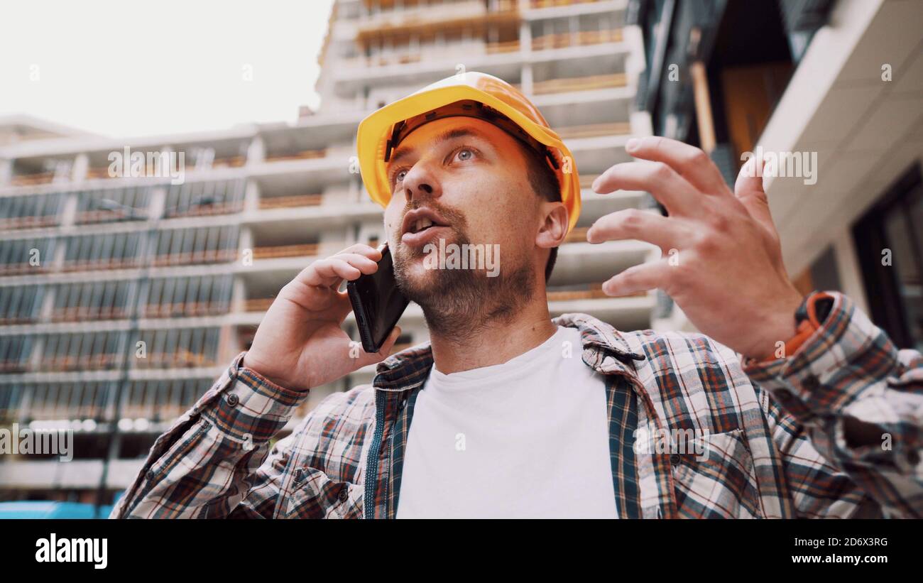 Engineer talking on phone. Architect using phone on construction site ...