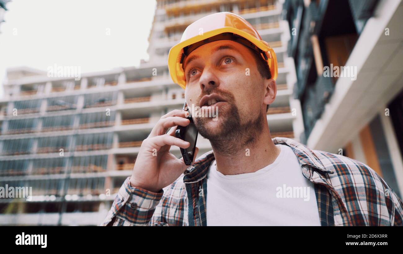 Engineer talking on phone. Architect using phone on construction site ...