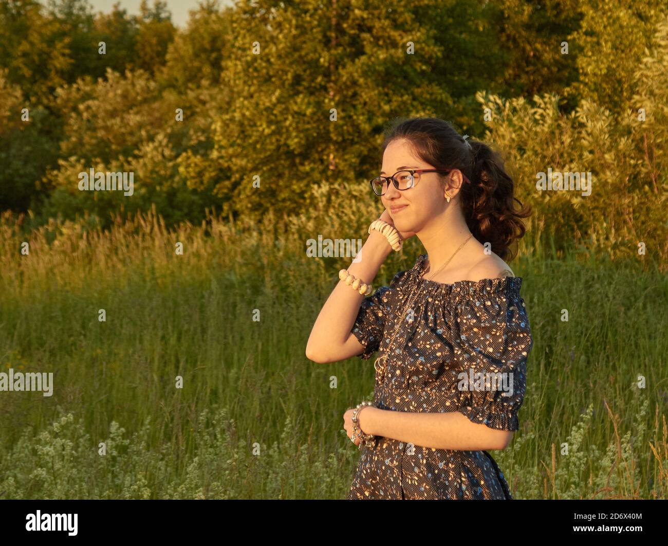 portrait of a shy girl against a background of trees Stock Photo - Alamy