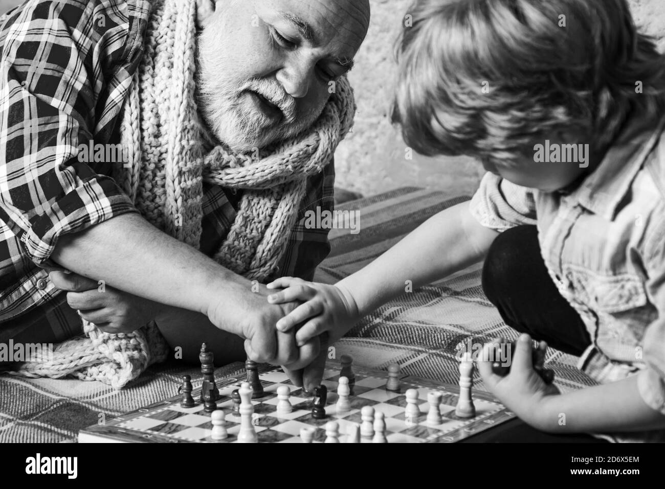 Handsome grandpa and grandson are playing chess while spending time ...