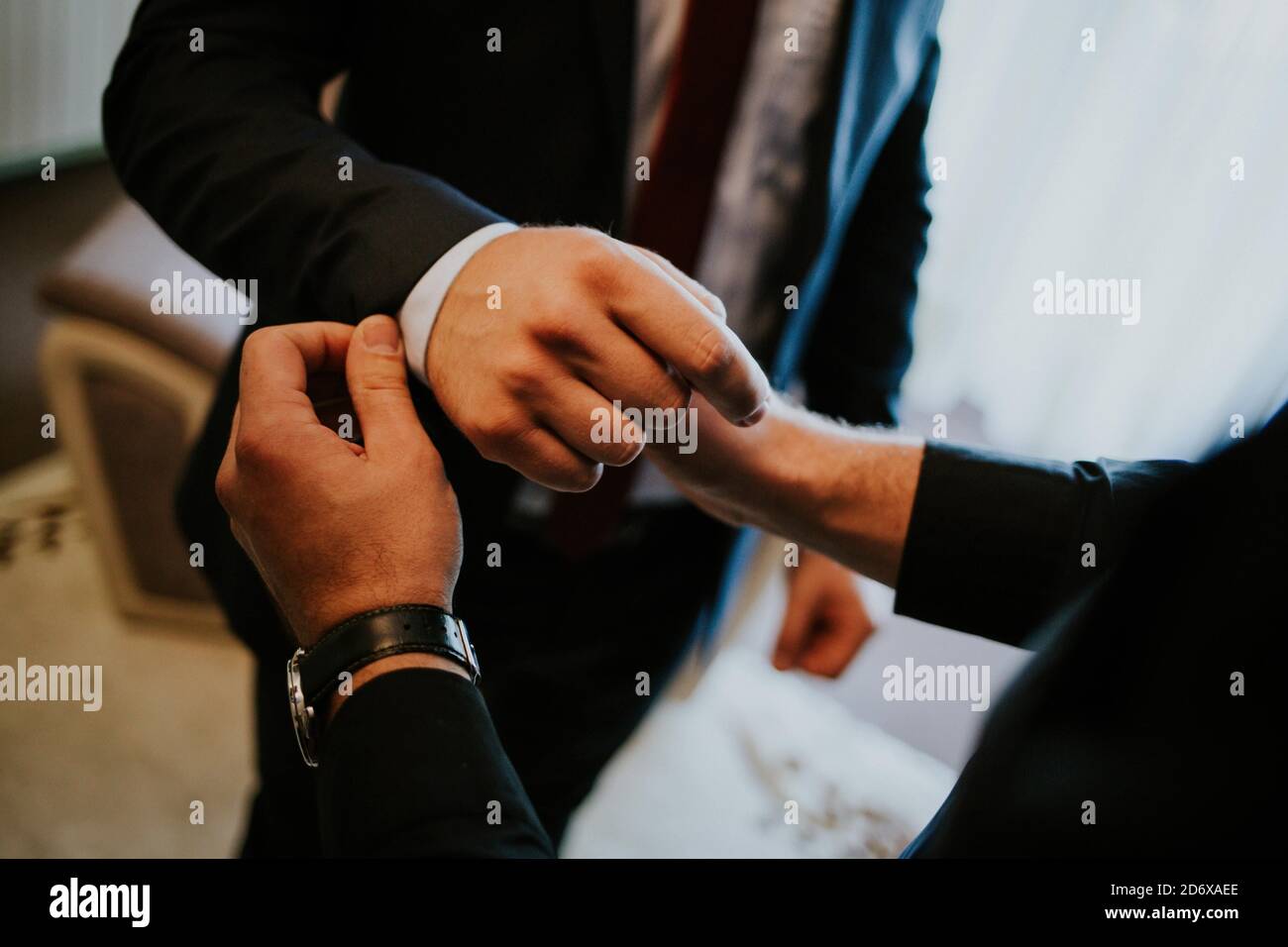 Groomsman helping groom to dress up Stock Photo - Alamy