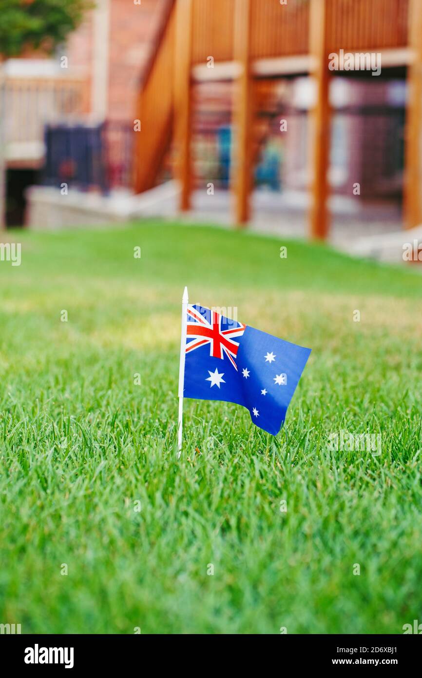 Australian flag standing on green grass in front of house. Australia ...