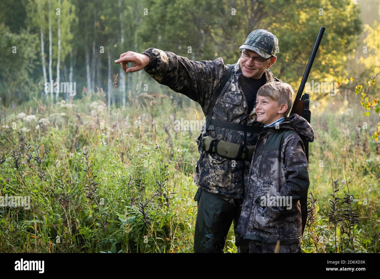 A young boy on the hunt with an experienced instructor in the forest ...