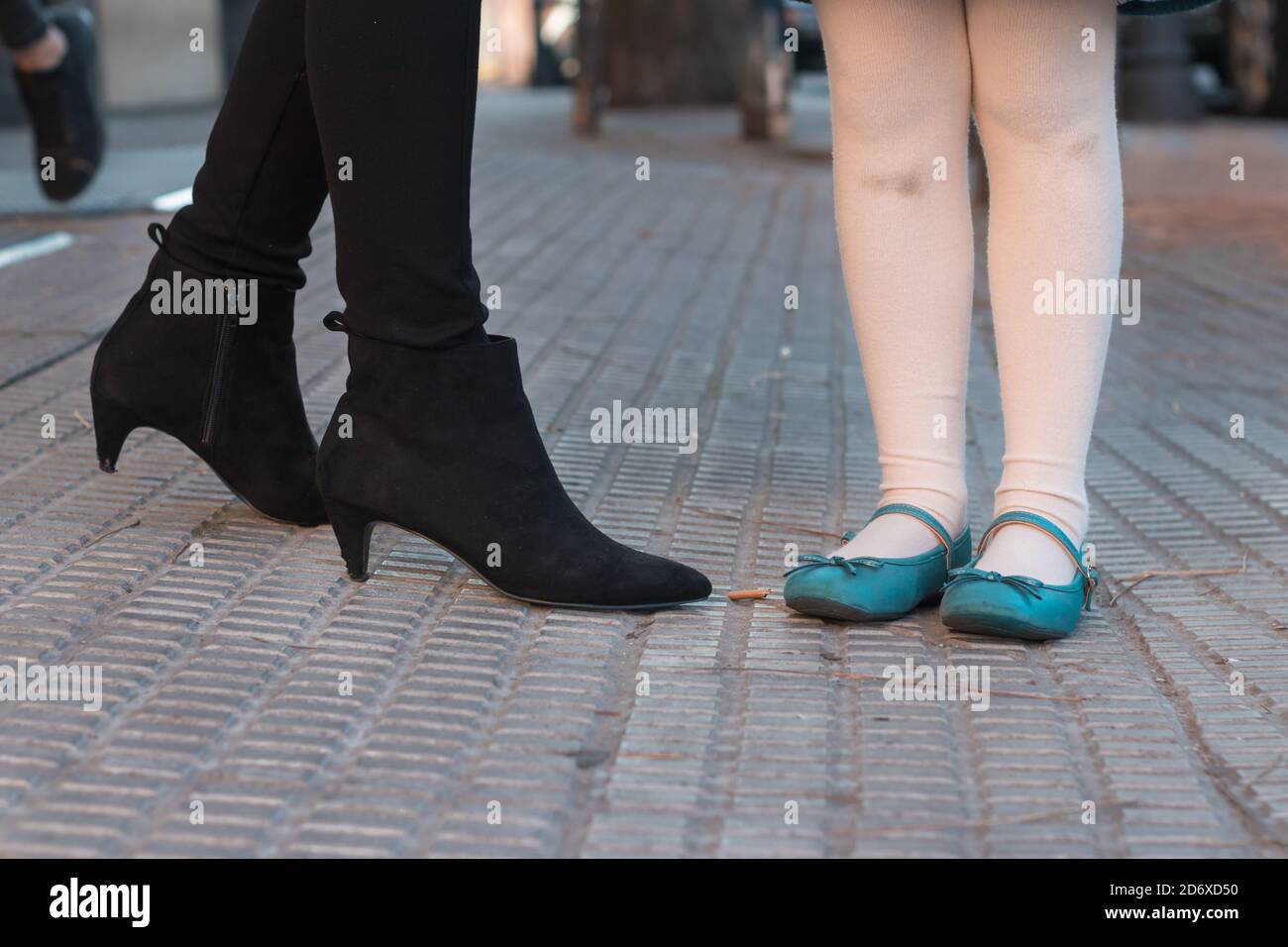 Human feet of a woman and a girl in the street, black boots and Mary ...