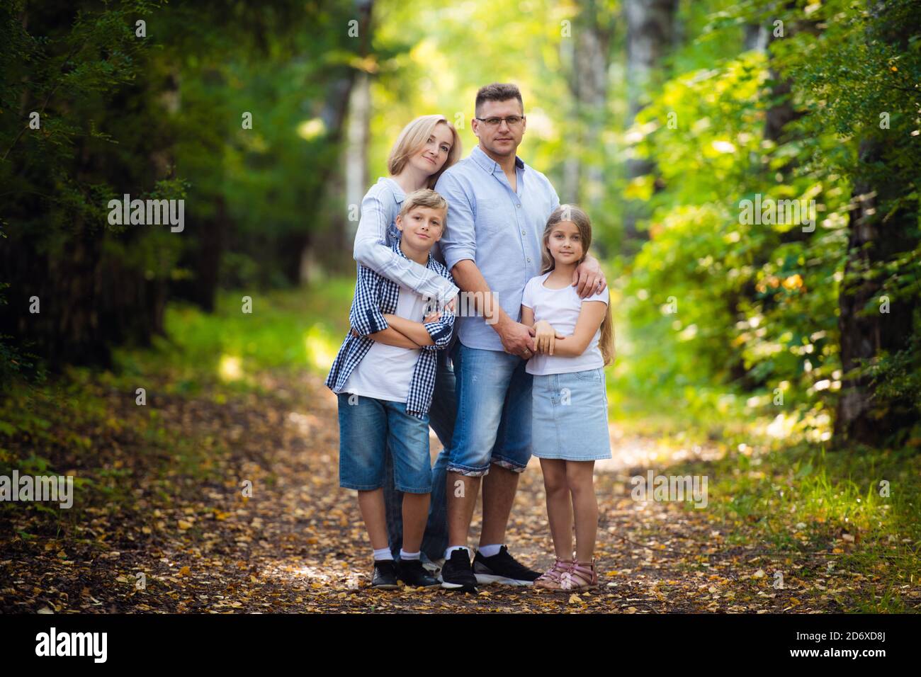 Happy family outdoor portrait in a forest Stock Photo - Alamy
