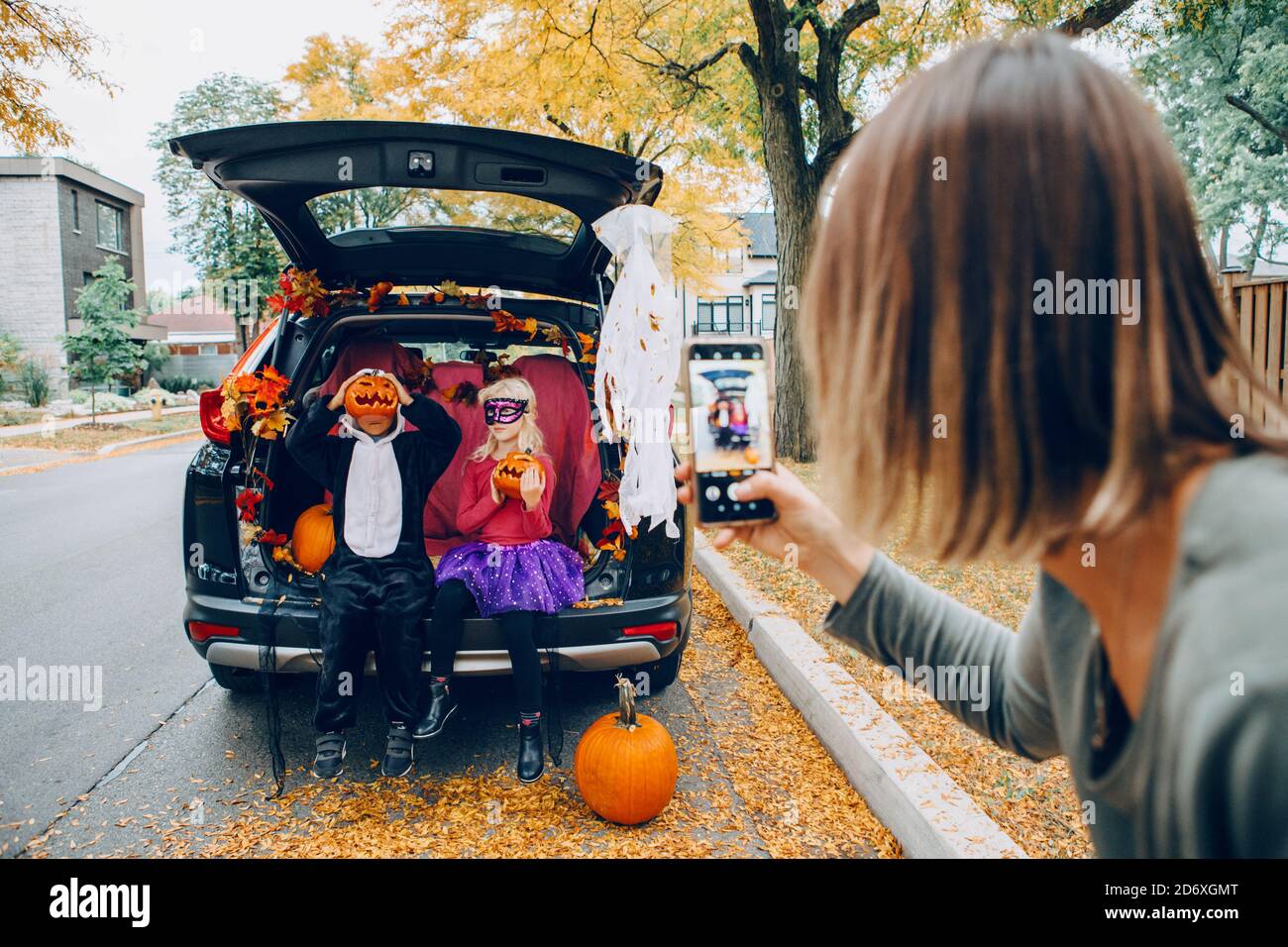 Trick or trunk. Children boy and girl with red pumpkins celebrating ...