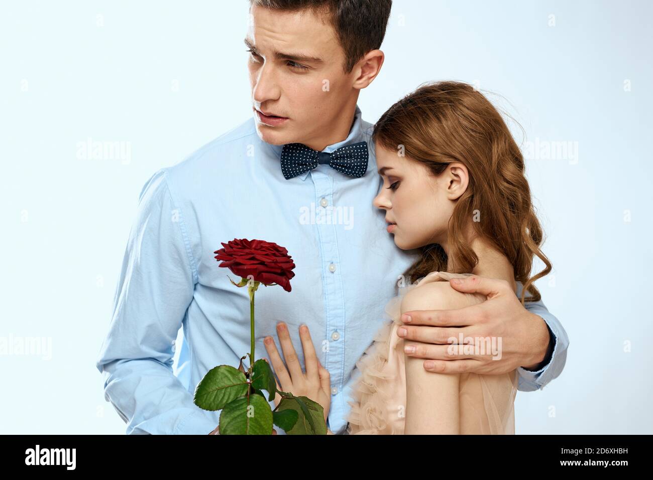 Man and woman with a red rose on a light background love family hugs ...