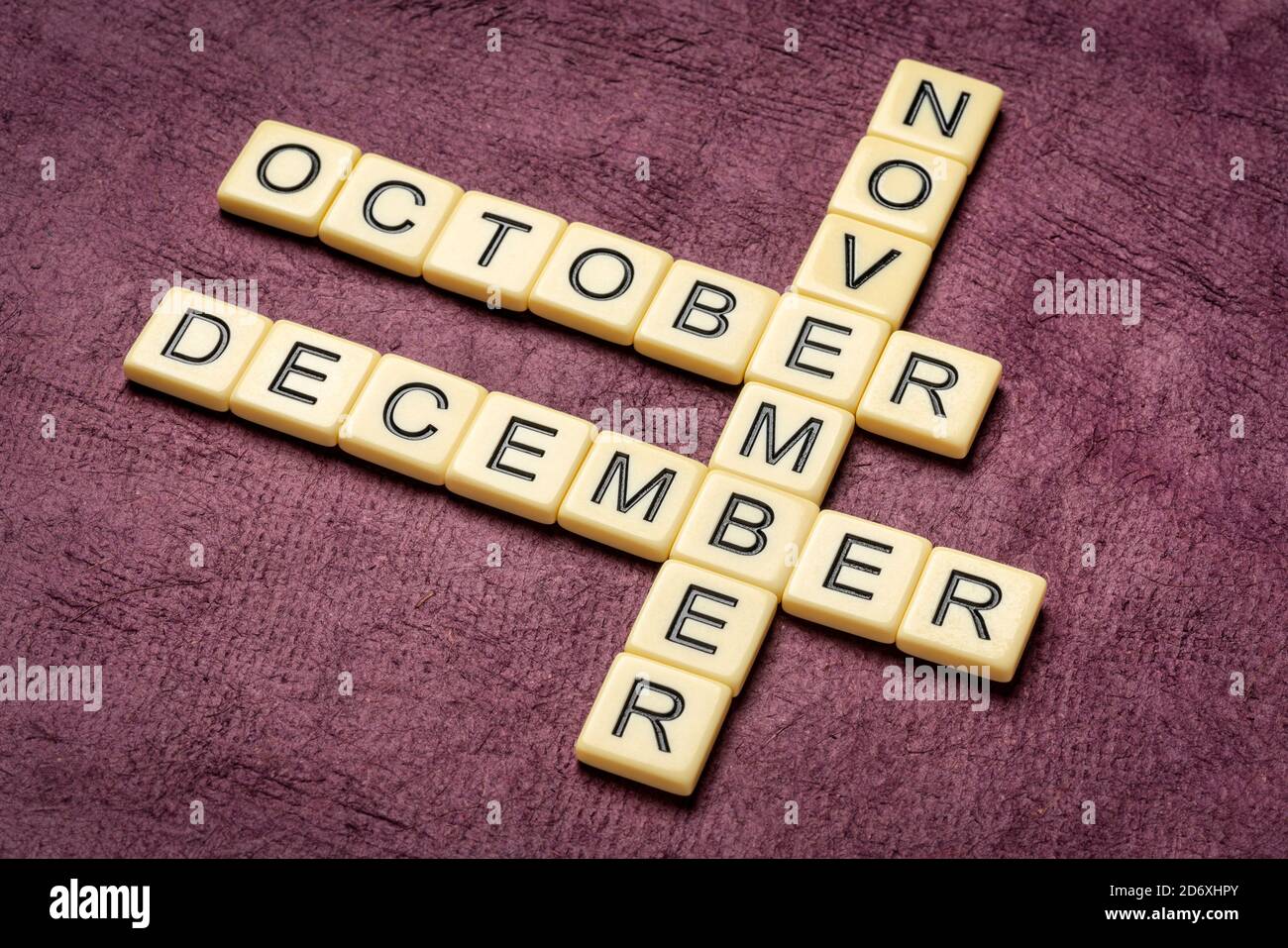 october, november and december crossword in ivory letter tiles against ...