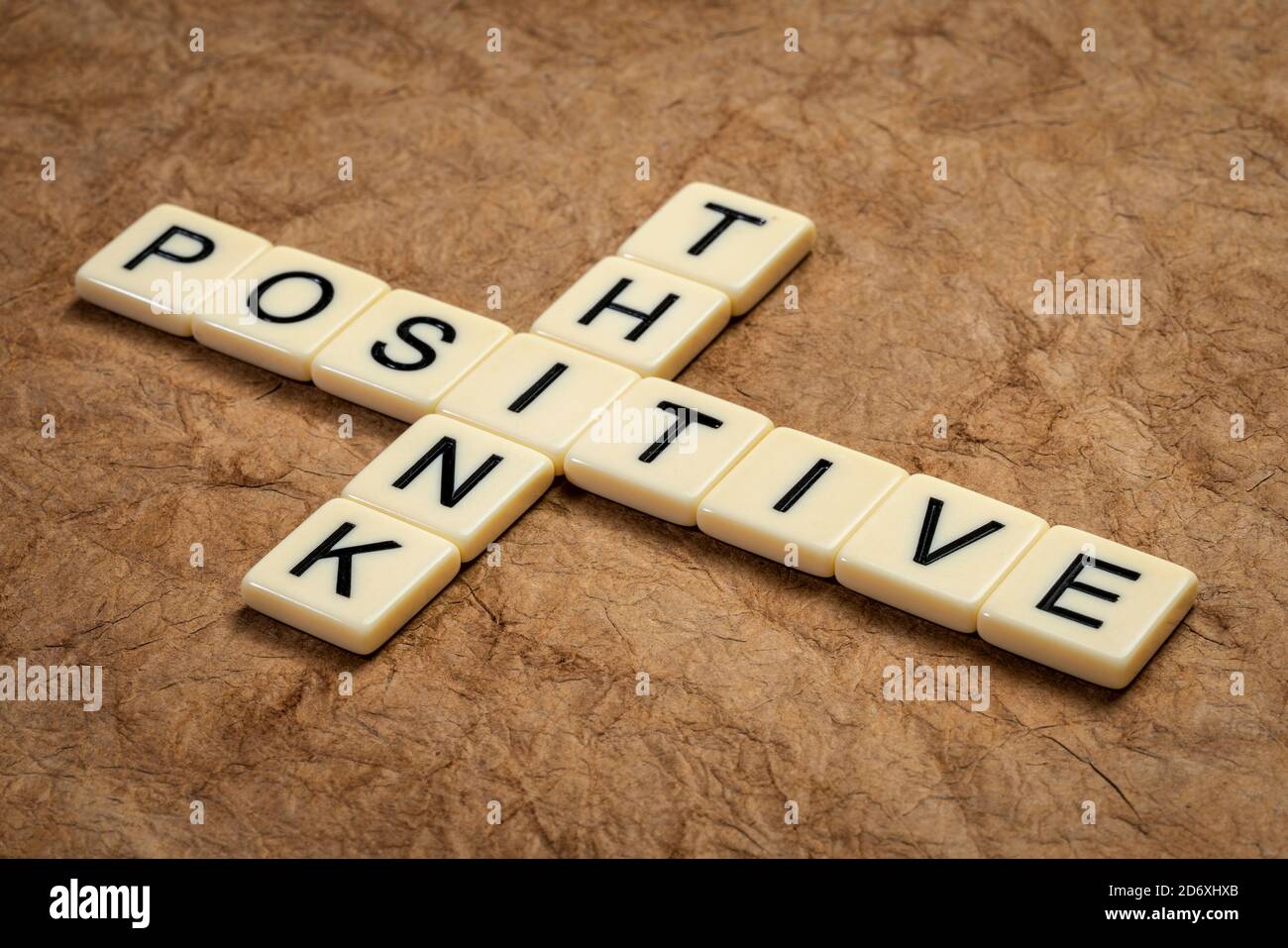 think positive crossword in ivory letter tiles against textured ...