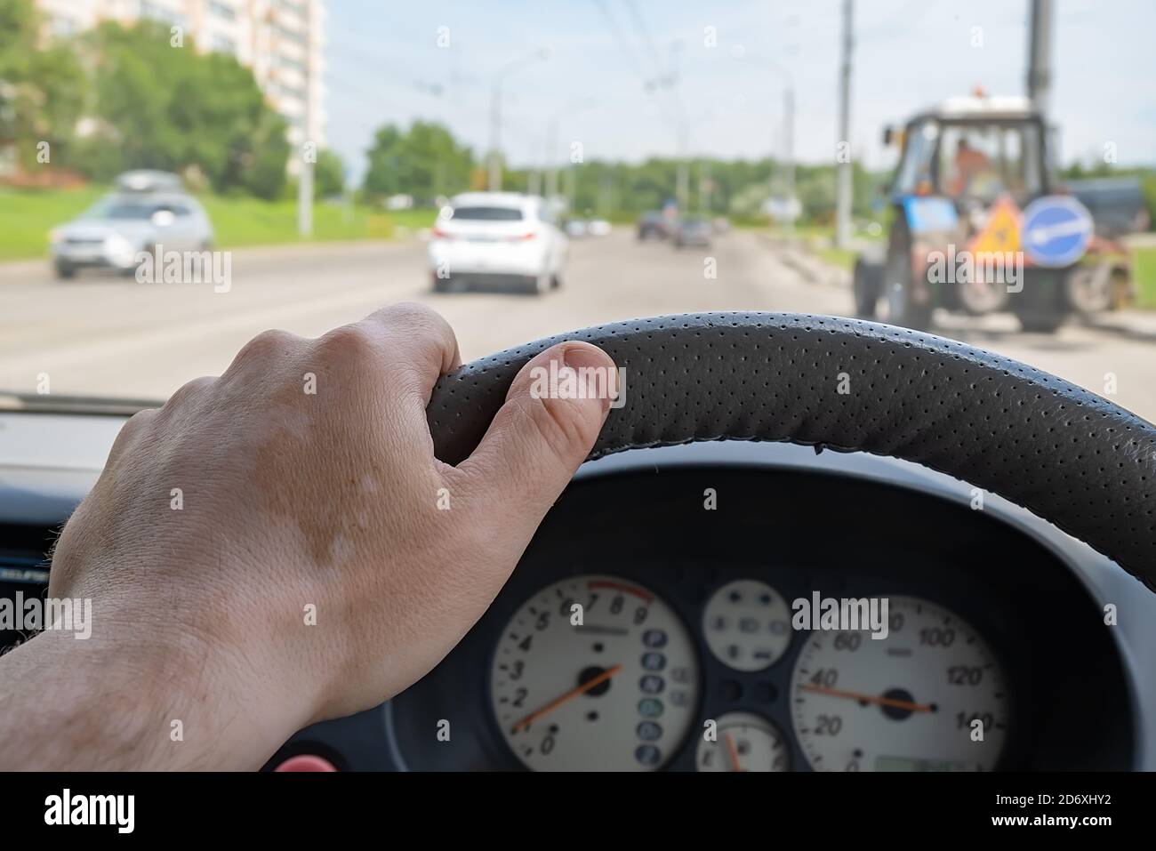 the driver's hand on the steering wheel of a car that is driving on the ...