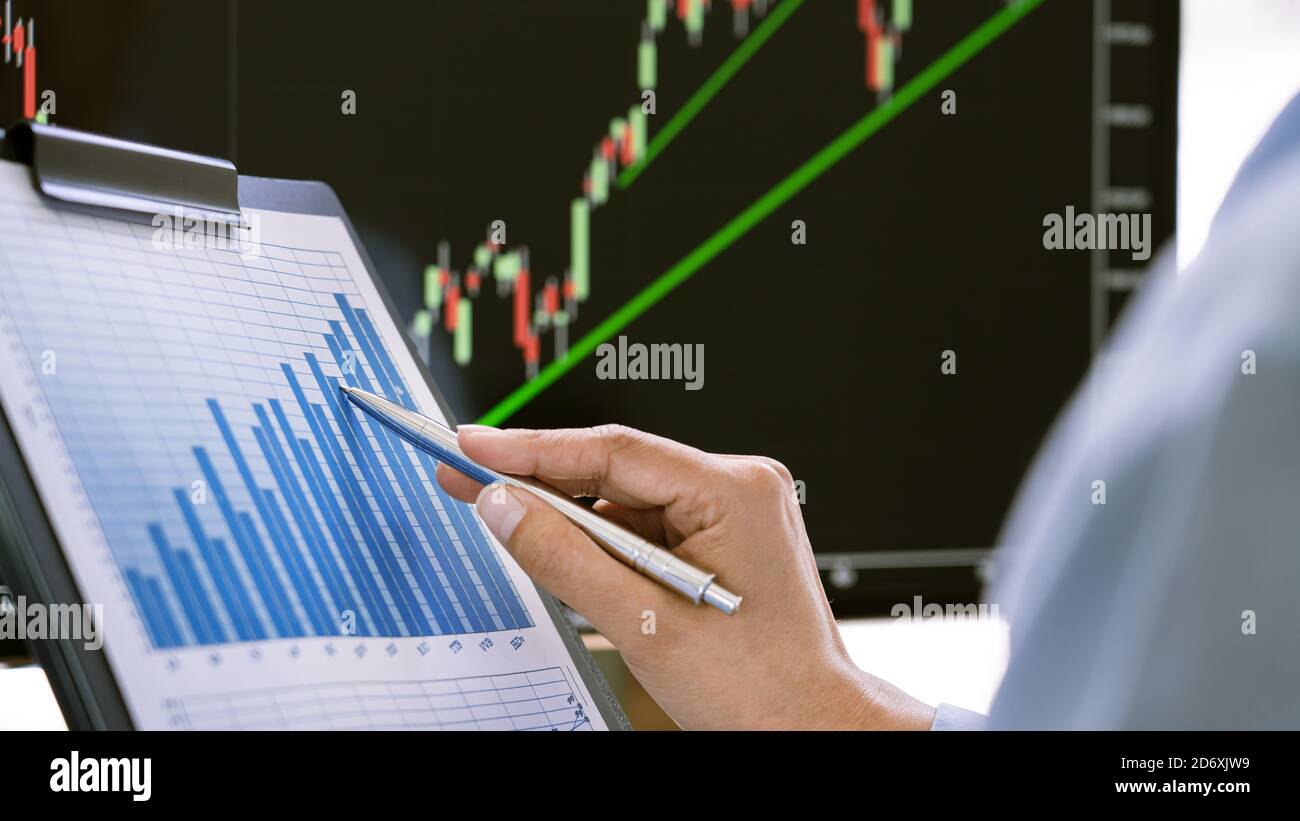 Stock Market Broker in formalwear Analyzing Graphs on screens in the ...