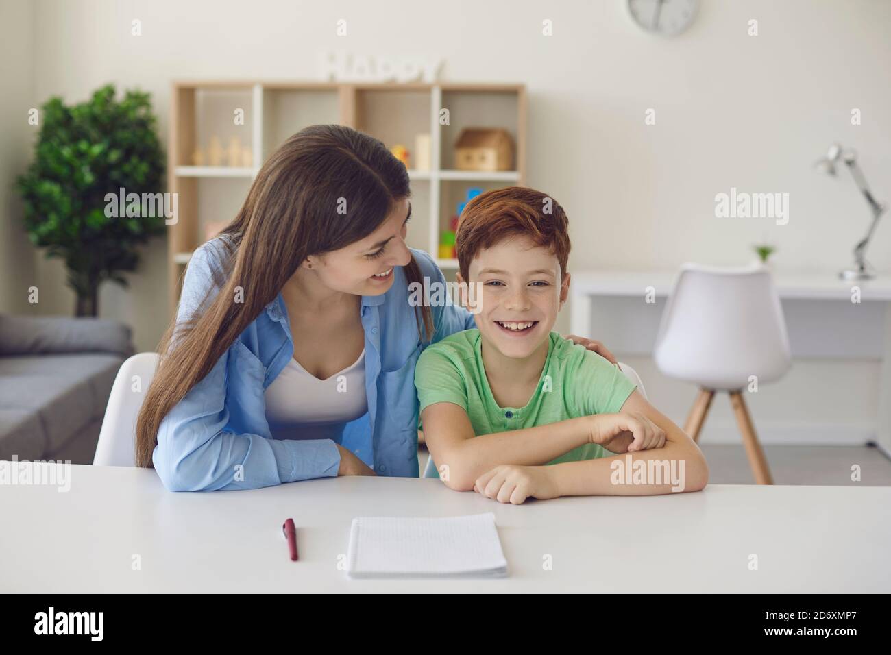 Little boy is going to write down tasks on a piece of paper with the ...