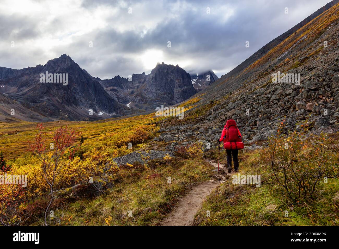 Woman Backpacking on Scenic Hiking Trail surrounded by Rugged Mountains ...