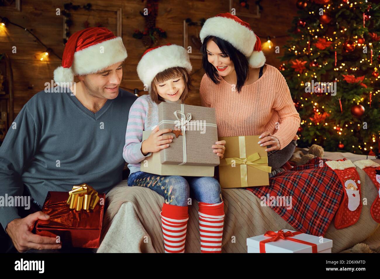 Family gives daughter a gift in the room at Christmas Stock Photo - Alamy
