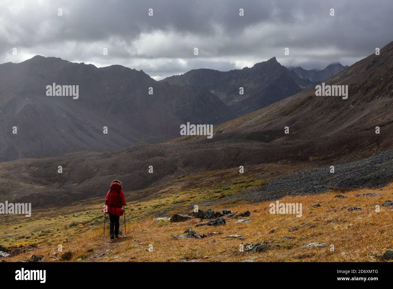 Woman Backpacking on Scenic Hiking Trail surrounded by Rugged Mountains ...