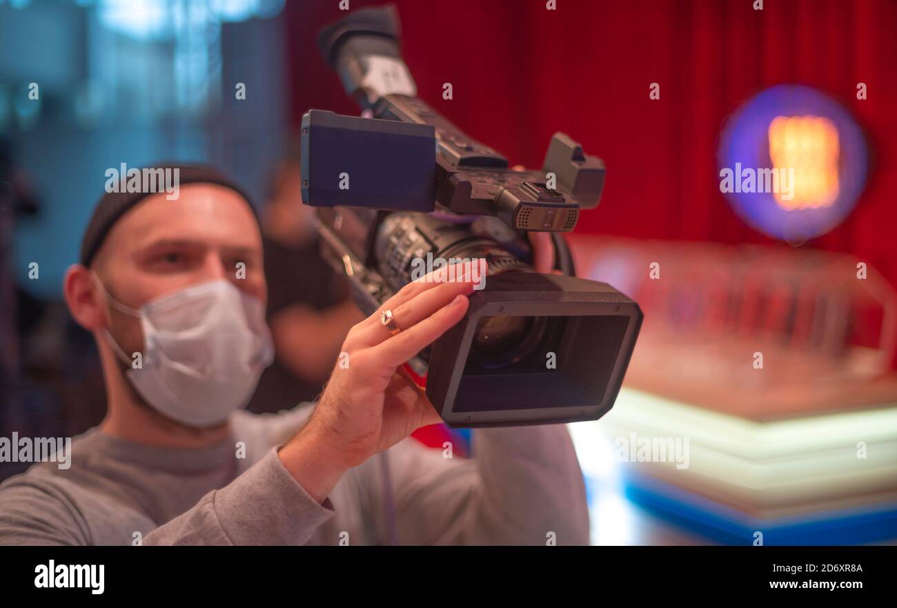masked cameraman is filming a television show in the studio. TV Stock ...