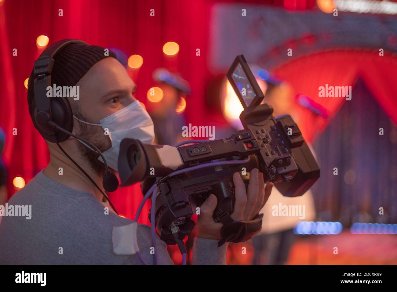 masked cameraman is filming a television show in the studio. TV Stock ...