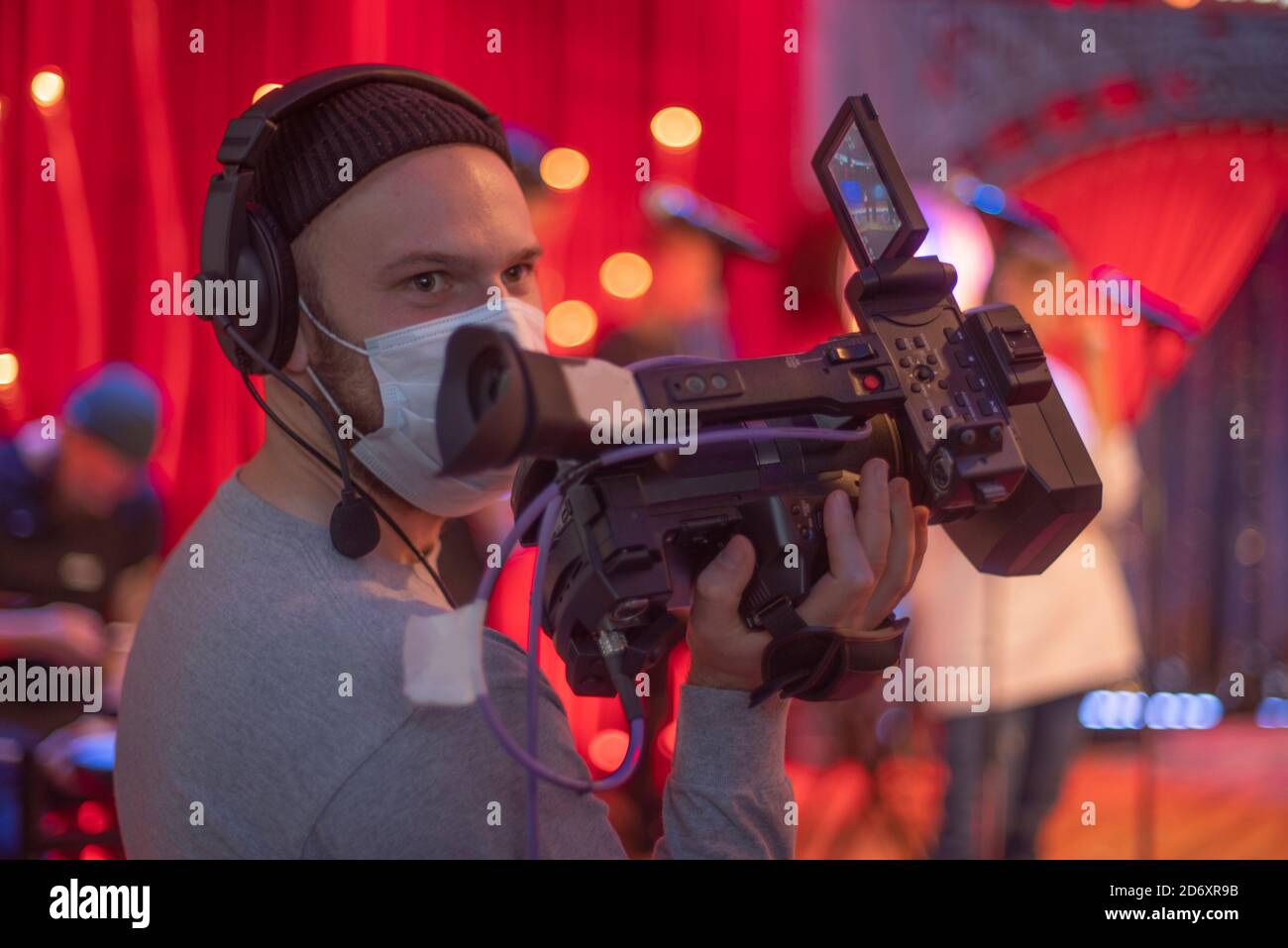 masked cameraman is filming a television show in the studio. TV Stock ...