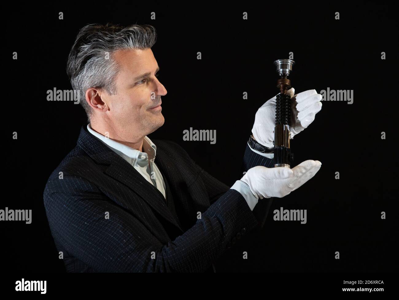 Prop Store CEO Stephen Lane holds Obi-Wan Kenobi's (Ewan McGregor ...