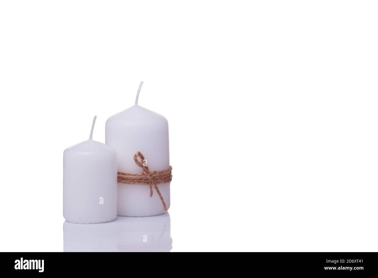 two white candles of different sizes, one wrapped in jute rope ...