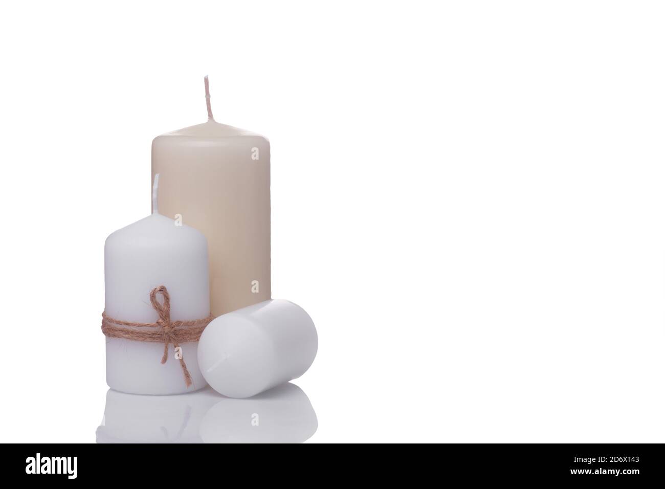 one white candle in jute rope, one white candle lying on its side and ...