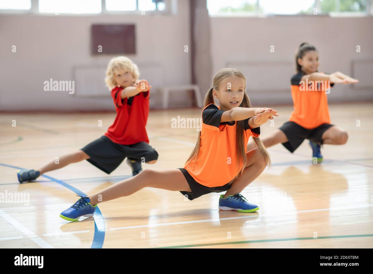 Three kids exercising in the gym and looking concentrated Stock Photo ...