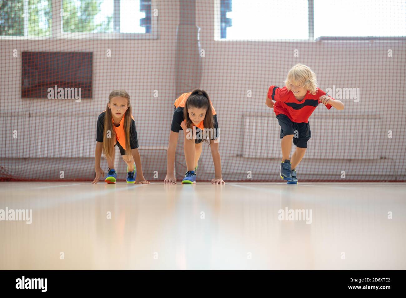 Kids in bright sportswear starting competition Stock Photo - Alamy