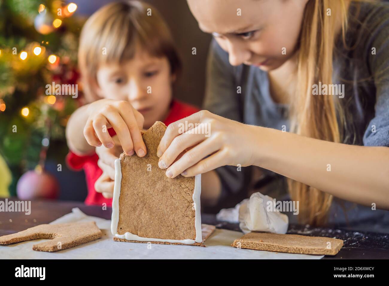 Young mother and kid making gingerbread house on Christmas eve Stock ...