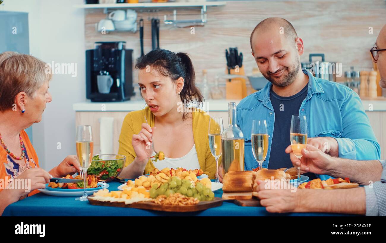 Extended family interacting while having a meal at dining table in the ...