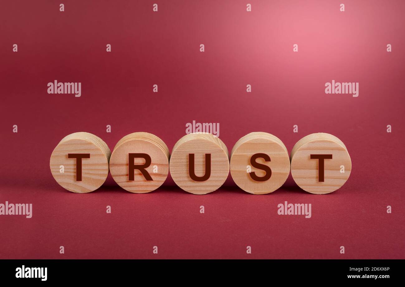 Trust sign on a wooden circles on a red Stock Photo - Alamy