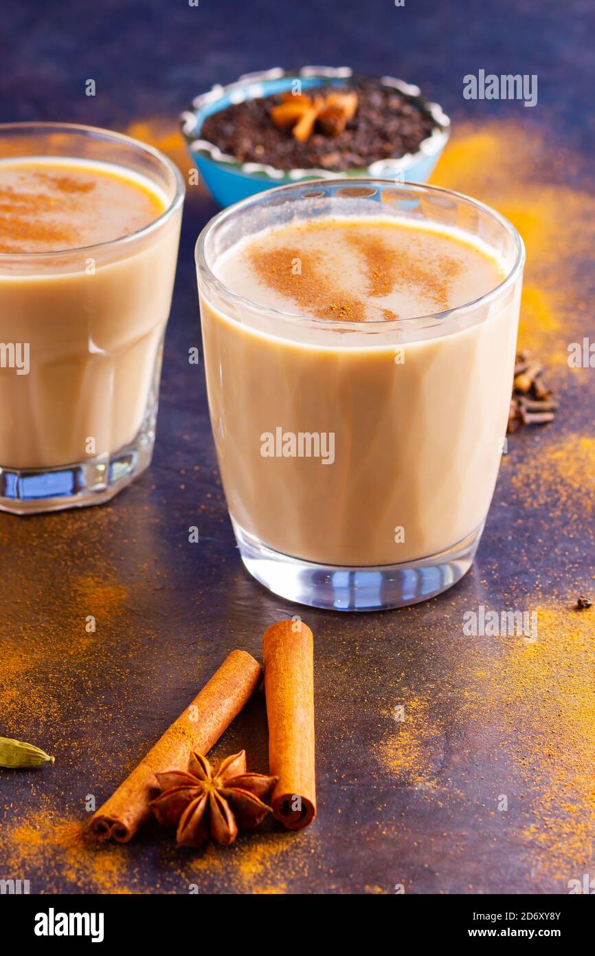 Masala chai tea on a black background. Two transparent glasses of ...