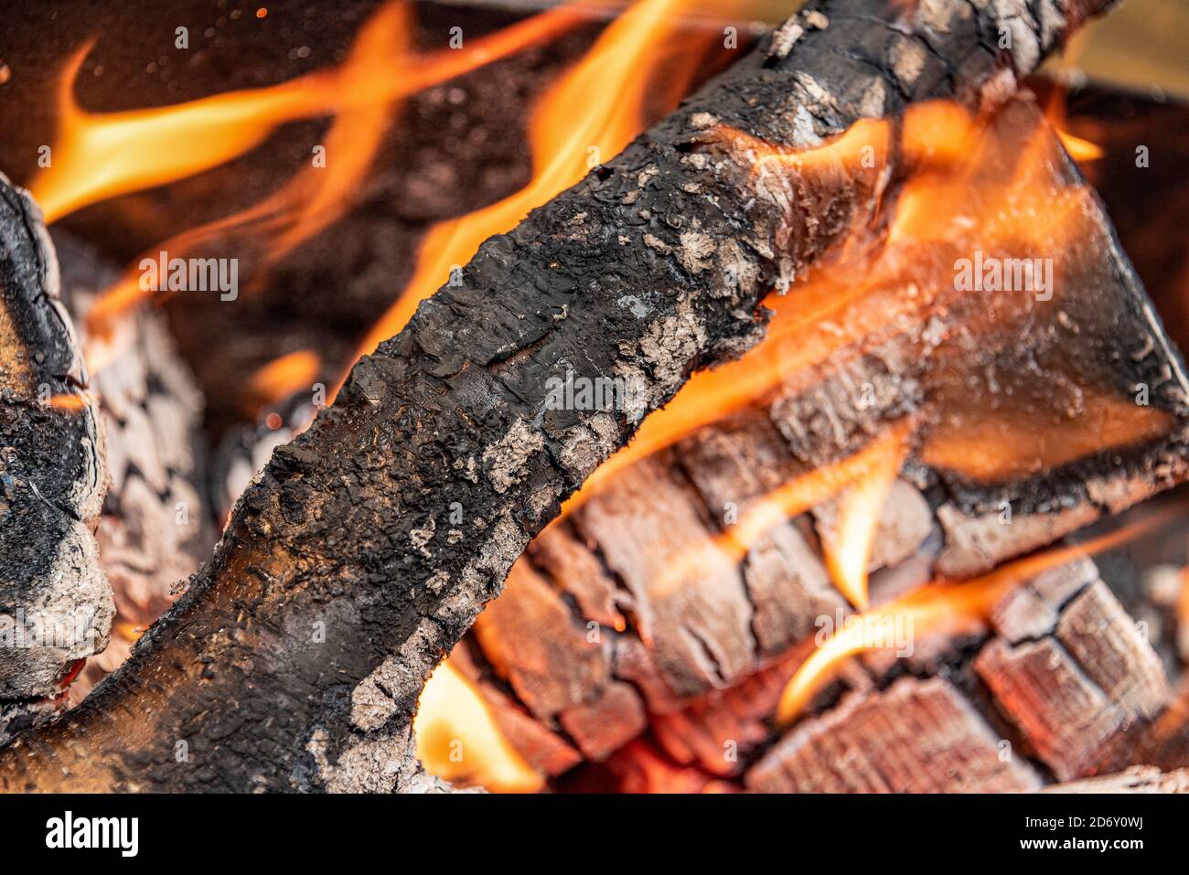 Yellow flame of fire on coals and logs. Background from burning logs ...