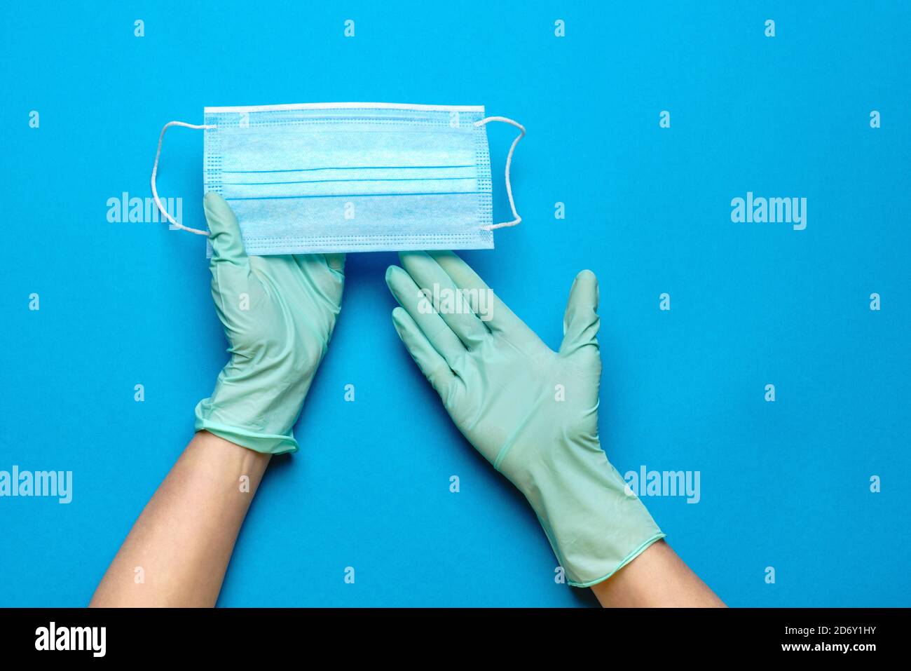 Human hand in protective gloves holding face protective mask isolated ...