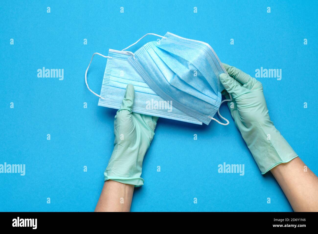 Human hand in protective gloves holding face protective mask isolated ...